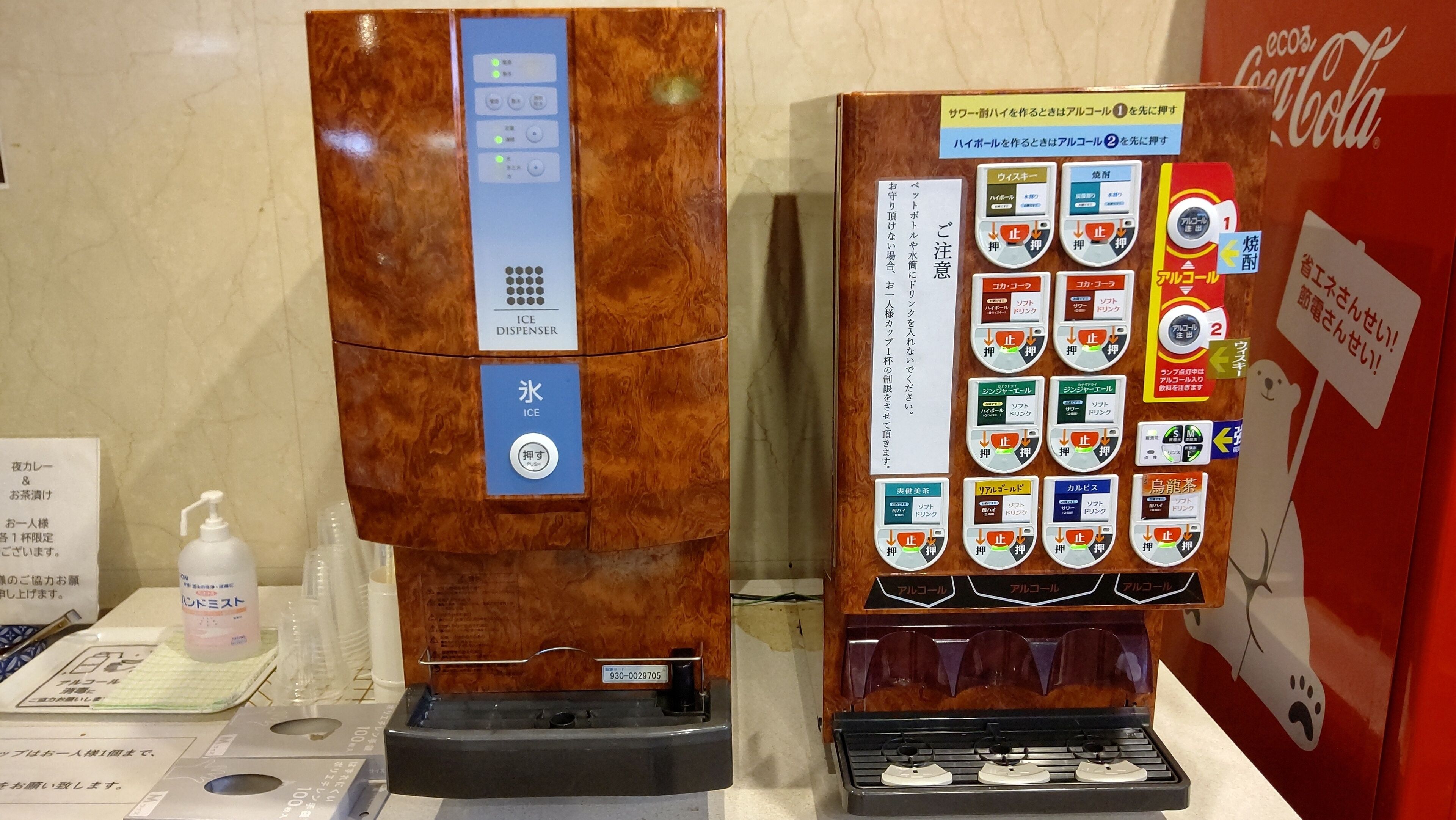 Máquina de vendas com diversas opções de bebidas e um dispensador da marca Coca-Cola.