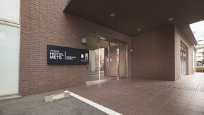 Entrada de hotel com uma placa indicando 'JR-EAST HOTEL METS KAMAKURA OFUNA'.