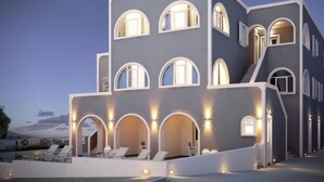 Um edifício moderno de vários andares com janelas em arco e área de piscina com espreguiçadeiras.