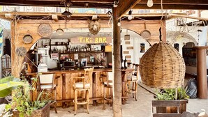 Um bar rústico com móveis de madeira e uma placa com a inscrição 