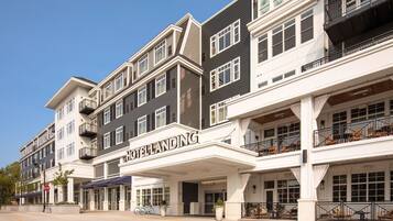Um hotel com uma placa grande que diz 'HOTELLANDING', uma entrada coberta e uma varanda com área de estar ao ar livre.