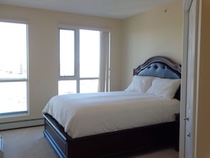 Um quarto com uma cama, janela e porta.