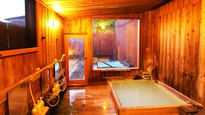 Uma cabana de madeira com sauna, um deck de madeira e uma porta de vidro que dá para o exterior.