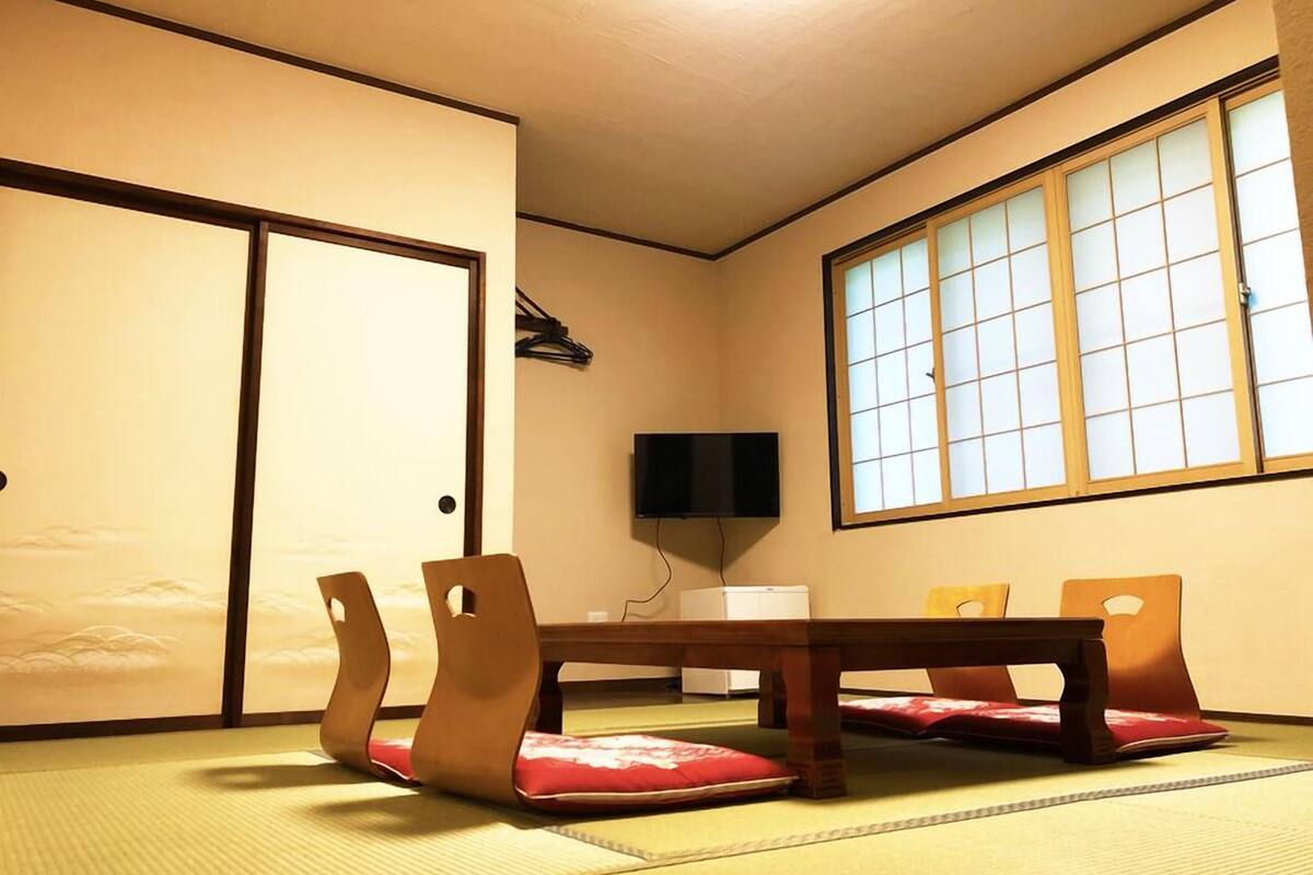 Um quarto japonês tradicional com tatames, uma mesa baixa e quatro cadeiras.