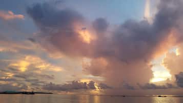 Na praia, praia de areia branca, espreguiçadeiras, guarda-sóis de praia