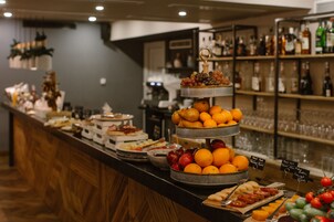 Buffet com diversos alimentos e área de bar com prateleiras de garrafas.