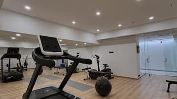 Uma academia moderna com esteiras, bolas de exercício e aparelhos de musculação.