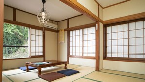 Um quarto japonês tradicional com tatames, uma mesa de madeira e portas corrediças.