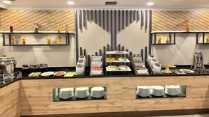 Uma mesa de buffet com diversos alimentos e acompanhamentos.