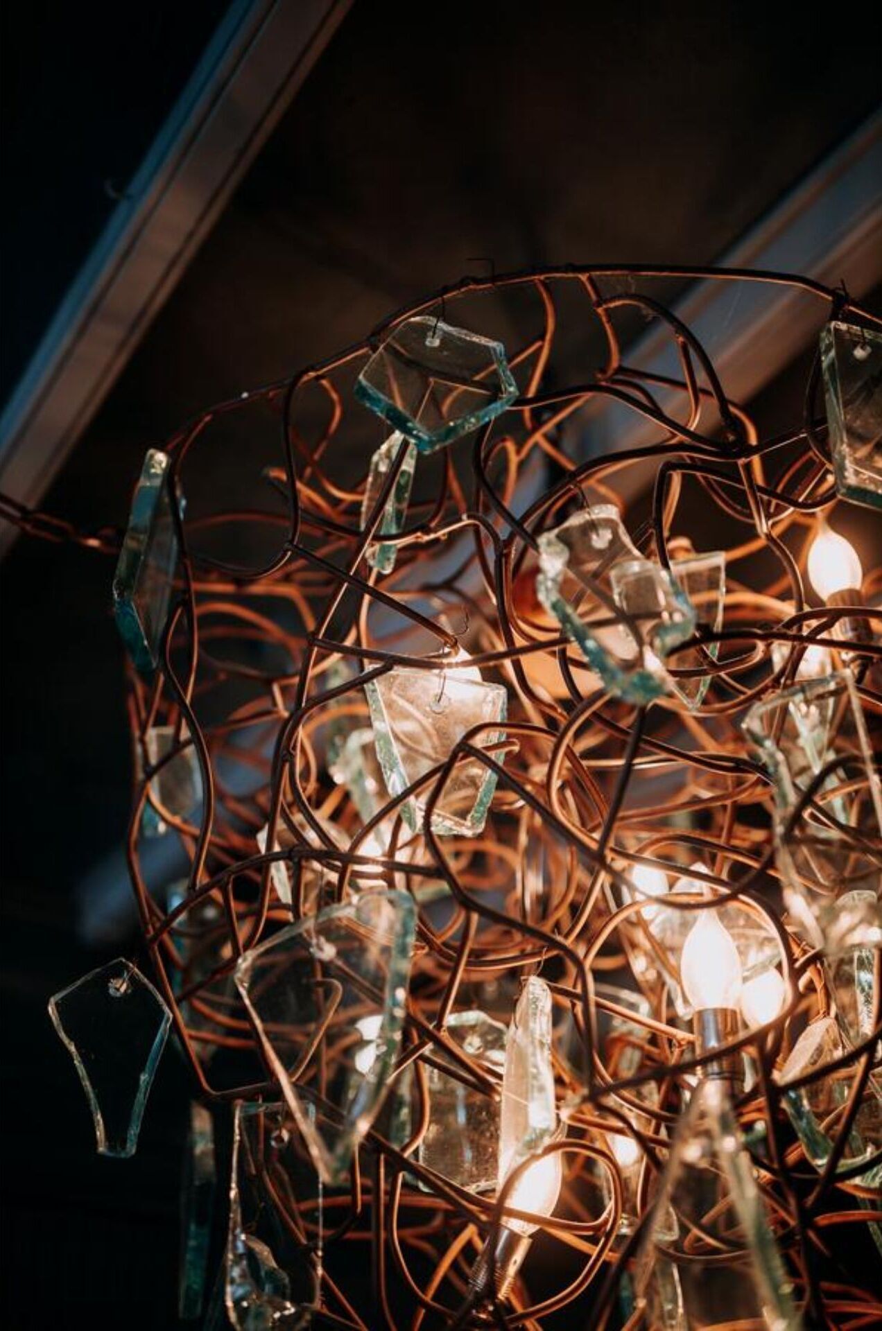 Um candelabro com várias lâmpadas de vidro e fios de cobre.