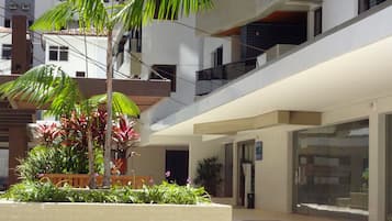 Um edifício moderno com um pátio central com uma palmeira e diversas plantas.