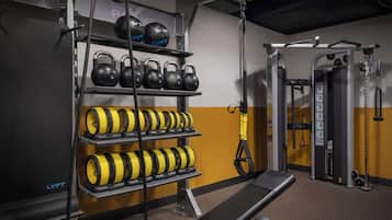 Uma academia com halteres, anilhas e equipamentos de ginástica.