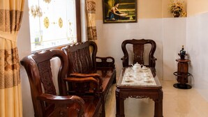 Quarto tradicional com móveis de madeira, um quadro na parede e um vaso com flores.