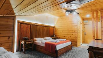 Quarto de cabana de madeira com cama, mesa de cabeceira e criado-mudo.