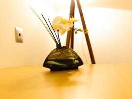 Um vaso preto com design único sobre uma mesa de madeira.