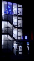 Um hotel com vários andares, varandas e uma placa com a inscrição 'BB ELUE HOTEL'.