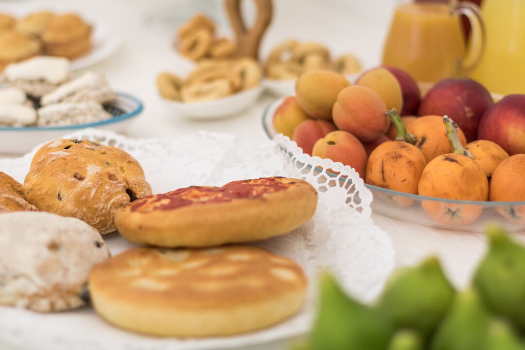 Diversos produtos de panificação e frutas frescas sobre uma mesa.