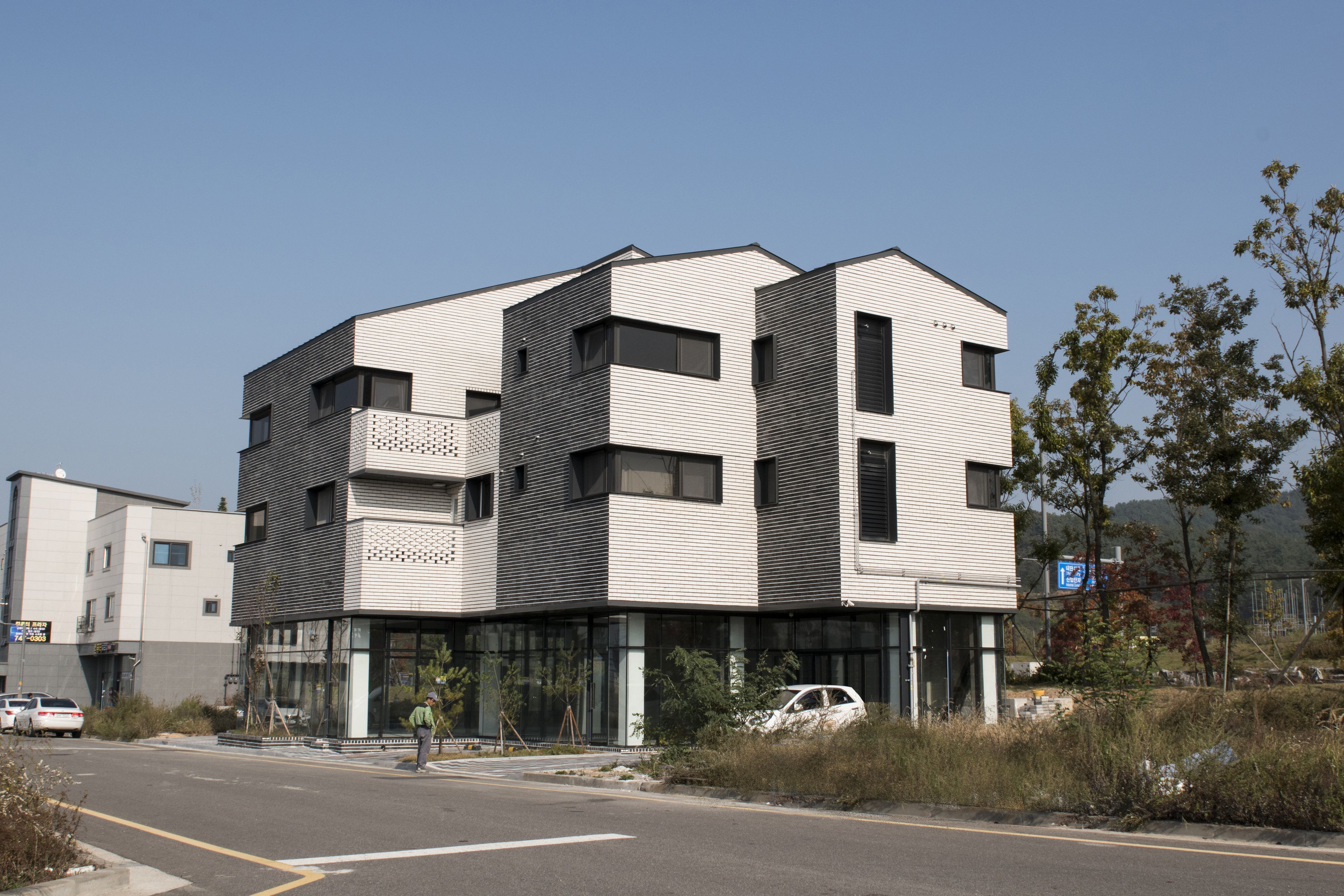Um edifício moderno de vários andares com telhado plano e janelas de diferentes tamanhos.
