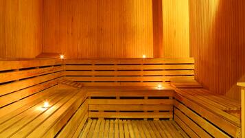 Uma sauna com bancos e paredes de madeira, e um banquinho no canto.