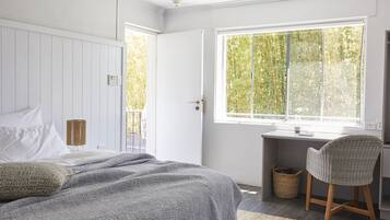 Quarto com cama, escrivaninha e cadeira.