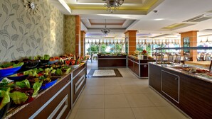 Uma área de buffet com diversos alimentos e uma ilha central.
