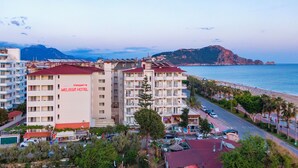 Um hotel com vários andares, varandas e vista para o mar.