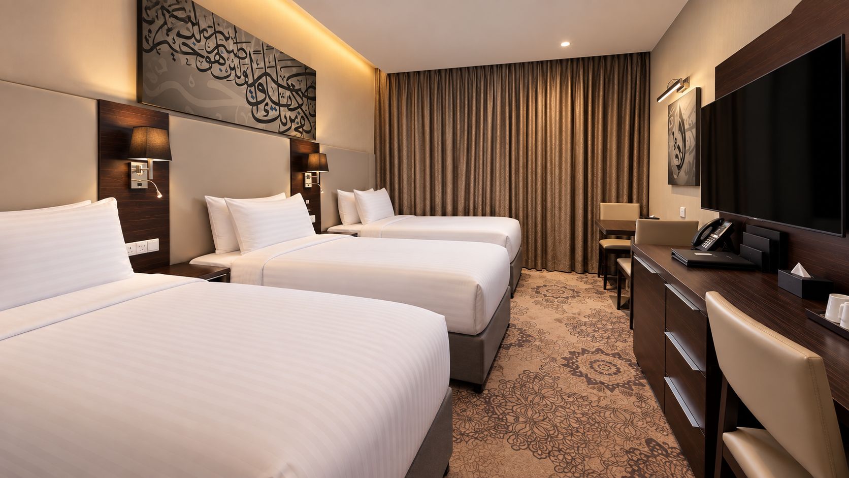 Quarto de hotel com duas camas, uma escrivaninha, televisão de tela plana e obras de arte nas paredes.