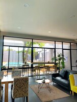 Interior moderno com vista para a piscina, área de refeições e um sofá.