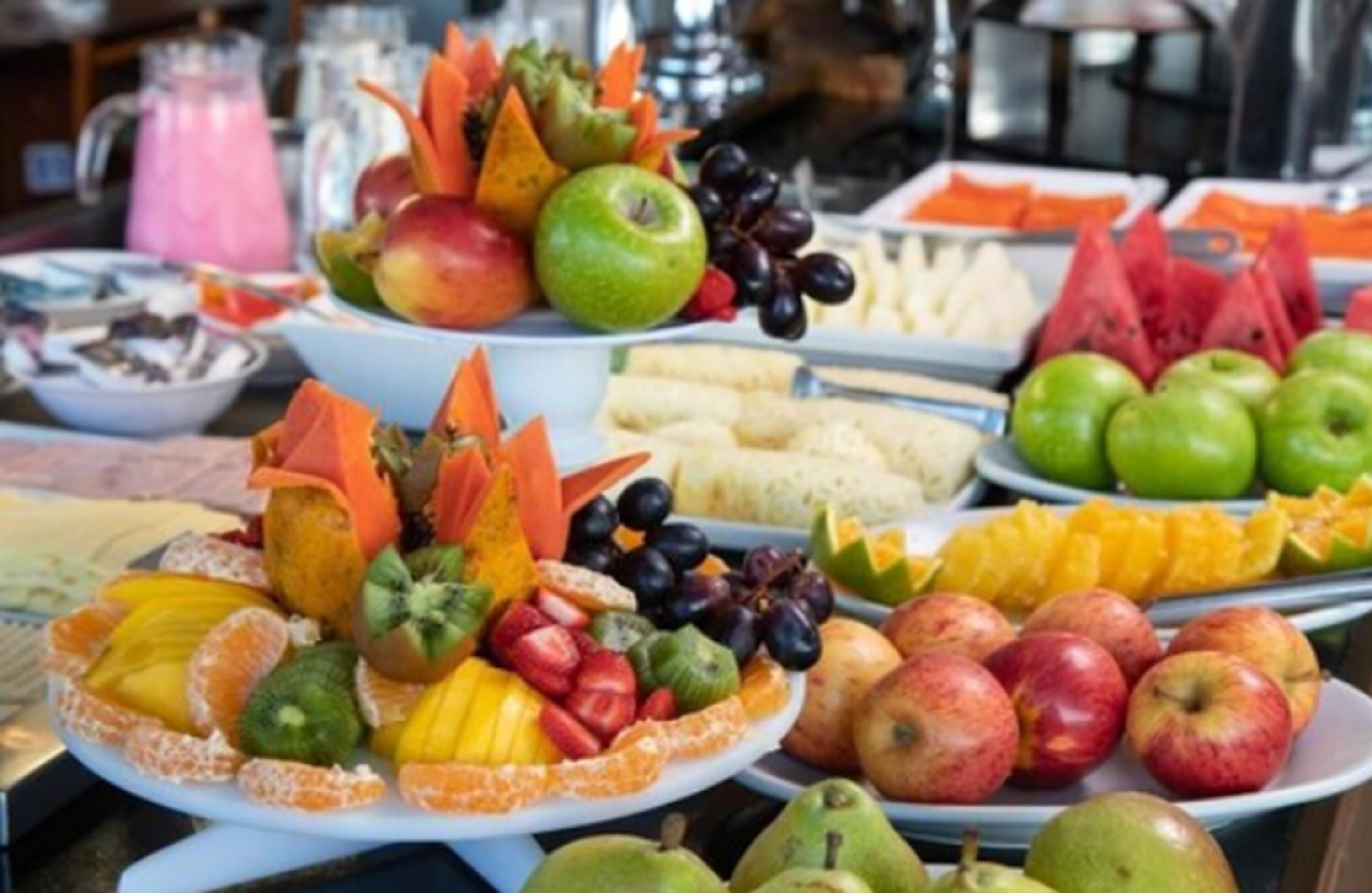 Um buffet com diversas frutas e lanches.