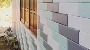 Um edifício com janela e parede decorada com padrão de azulejos em tons de azul claro e escuro.