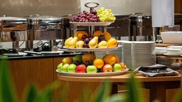 Buffet com diversas frutas e legumes, incluindo maçãs, laranjas e uvas.