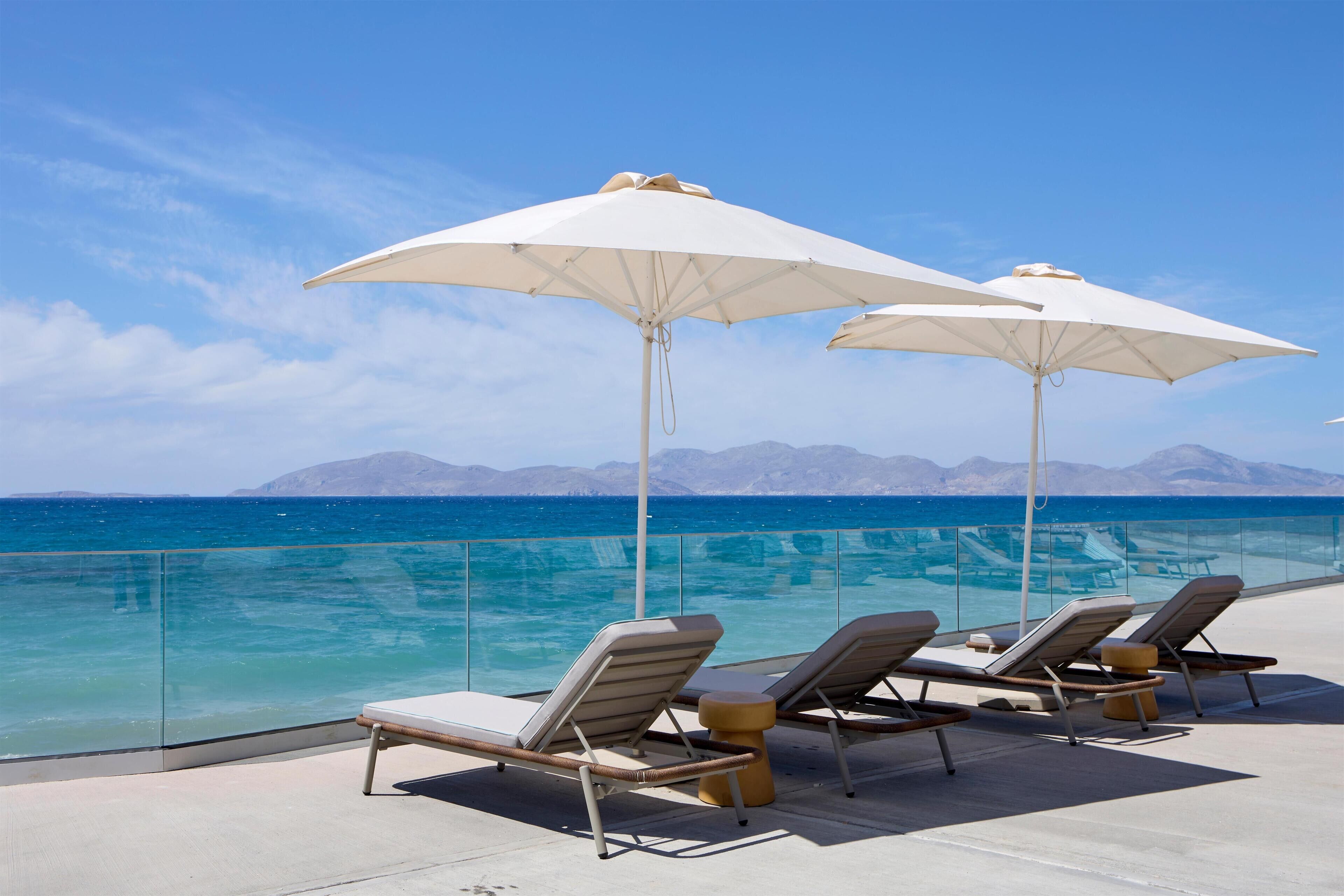 Na praia, espreguiçadeiras, guarda-sóis de praia, voleibol de praia 