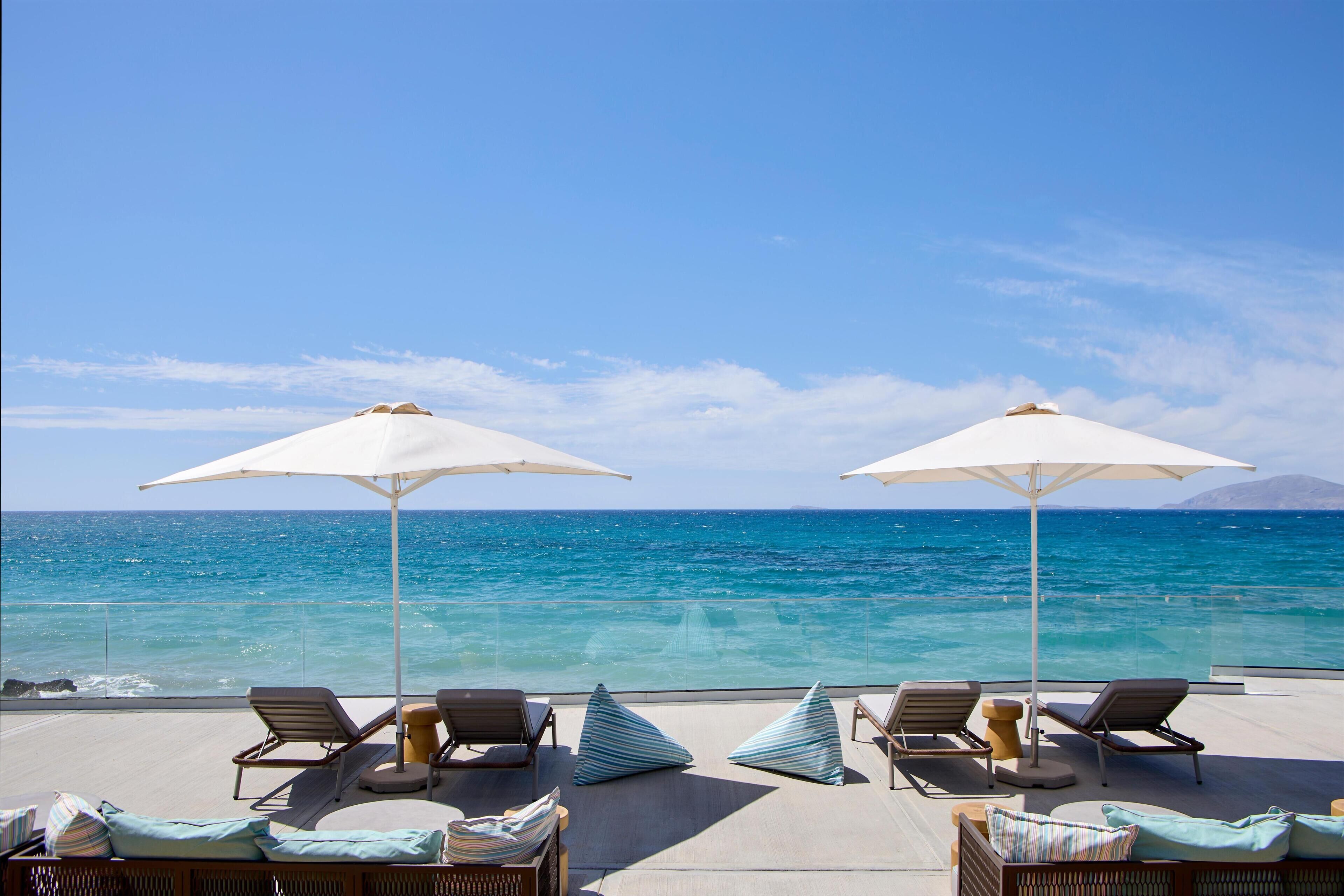 Na praia, espreguiçadeiras, guarda-sóis de praia, voleibol de praia 