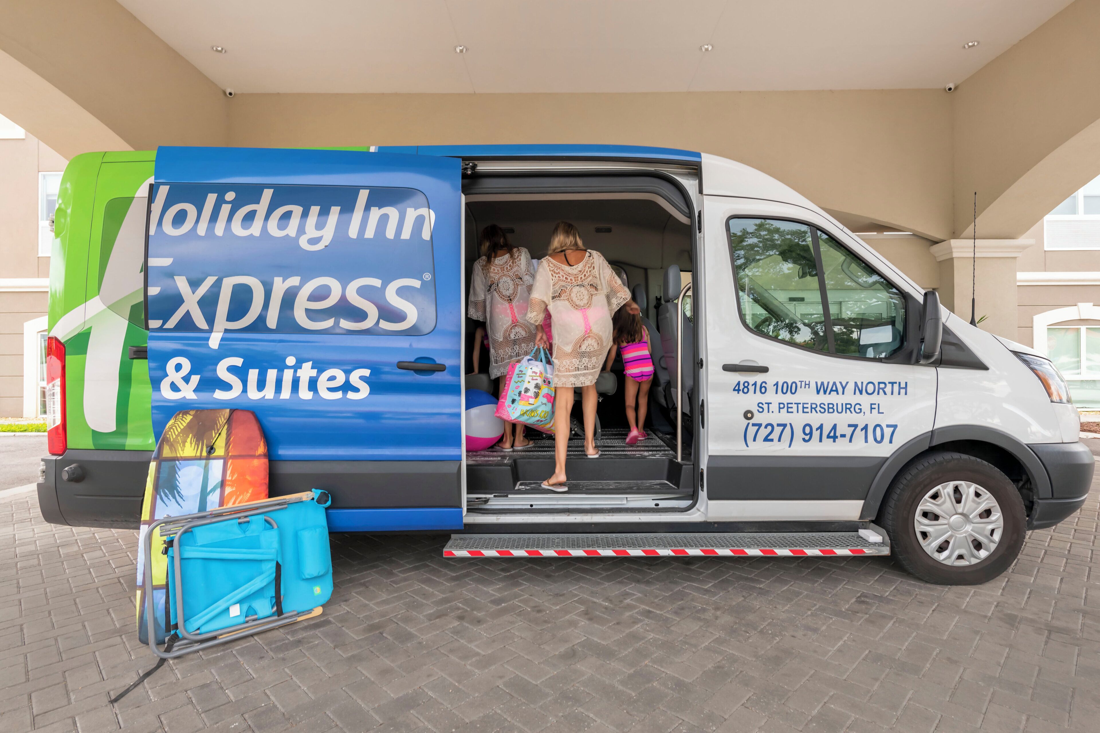 Van da Holiday Inn Express & Suites, com número de contato e endereço visíveis.