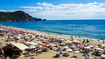 Perto da praia, espreguiçadeiras, guarda-sóis de praia