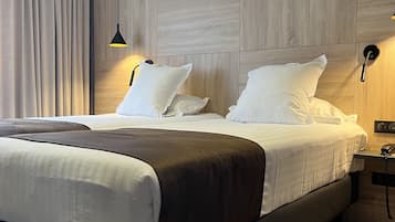 Quarto moderno com uma cama grande, painel de parede de madeira, duas luminárias de cabeceira e um telefone na mesa de apoio.