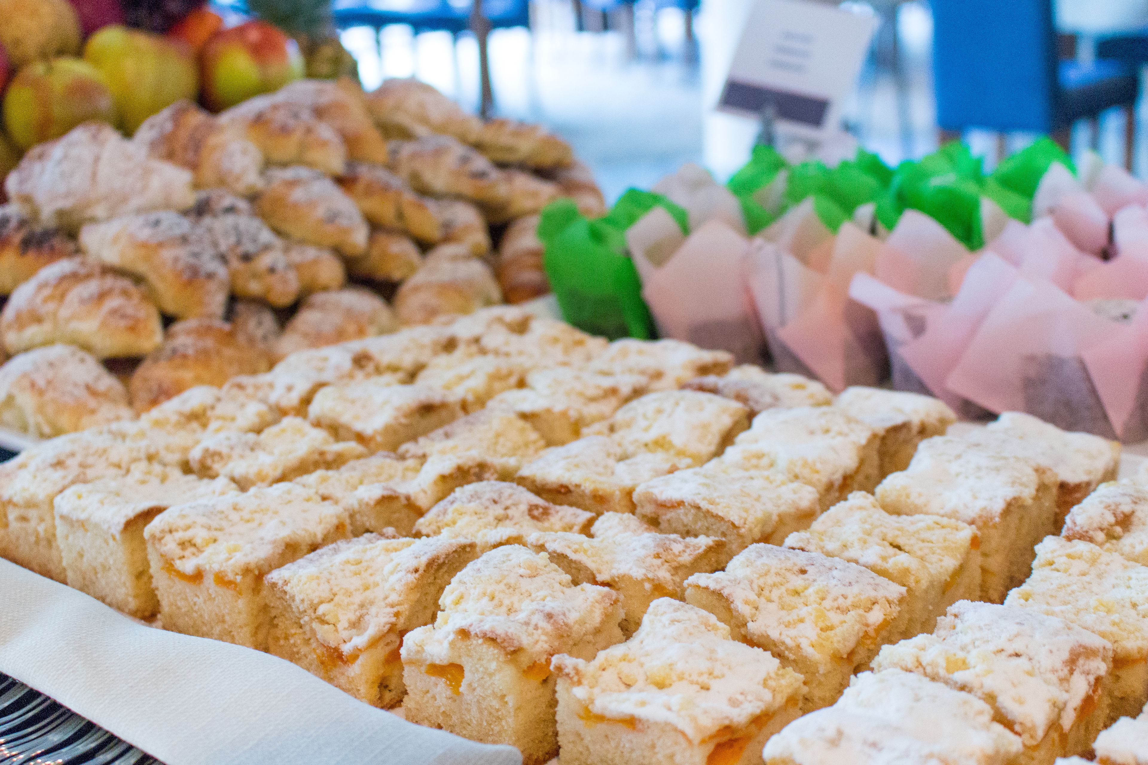 Diversos doces, incluindo scones e bolos, dispostos sobre uma mesa.