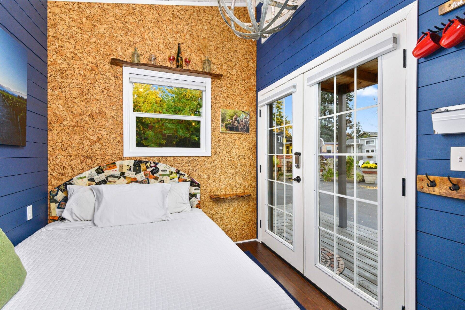 Quarto com cama, janela com vista e porta para o exterior.