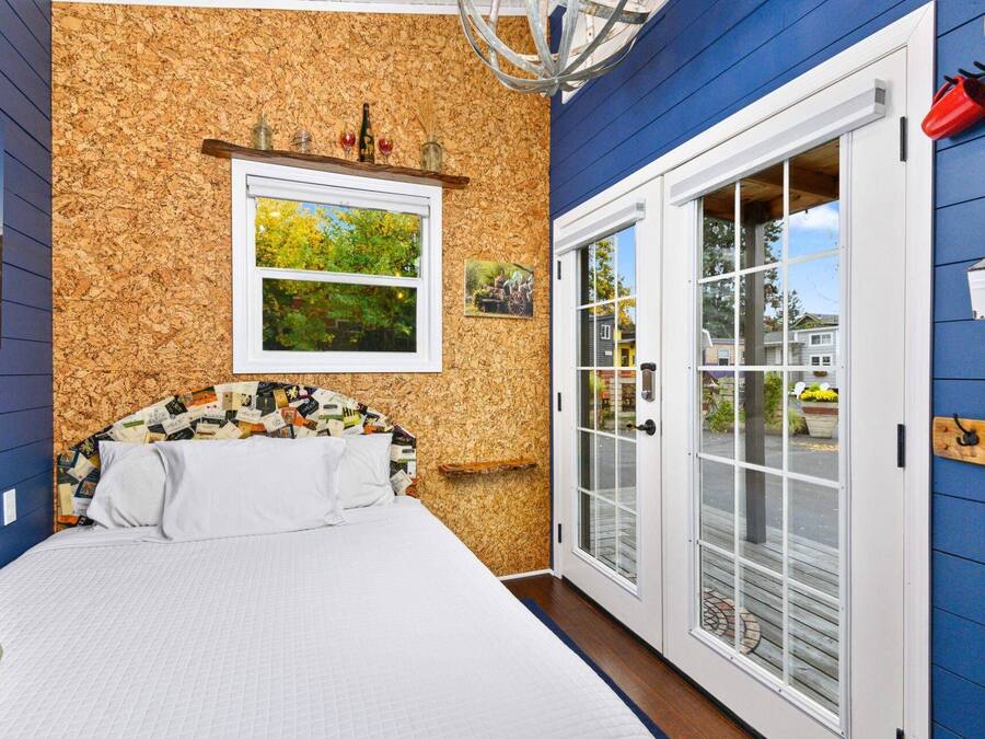 Quarto com cama, janela com vista e porta para o exterior.