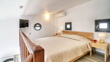 Quarto com cama de madeira, mesas de cabeceira, televisão na parede e janela com cortinas.