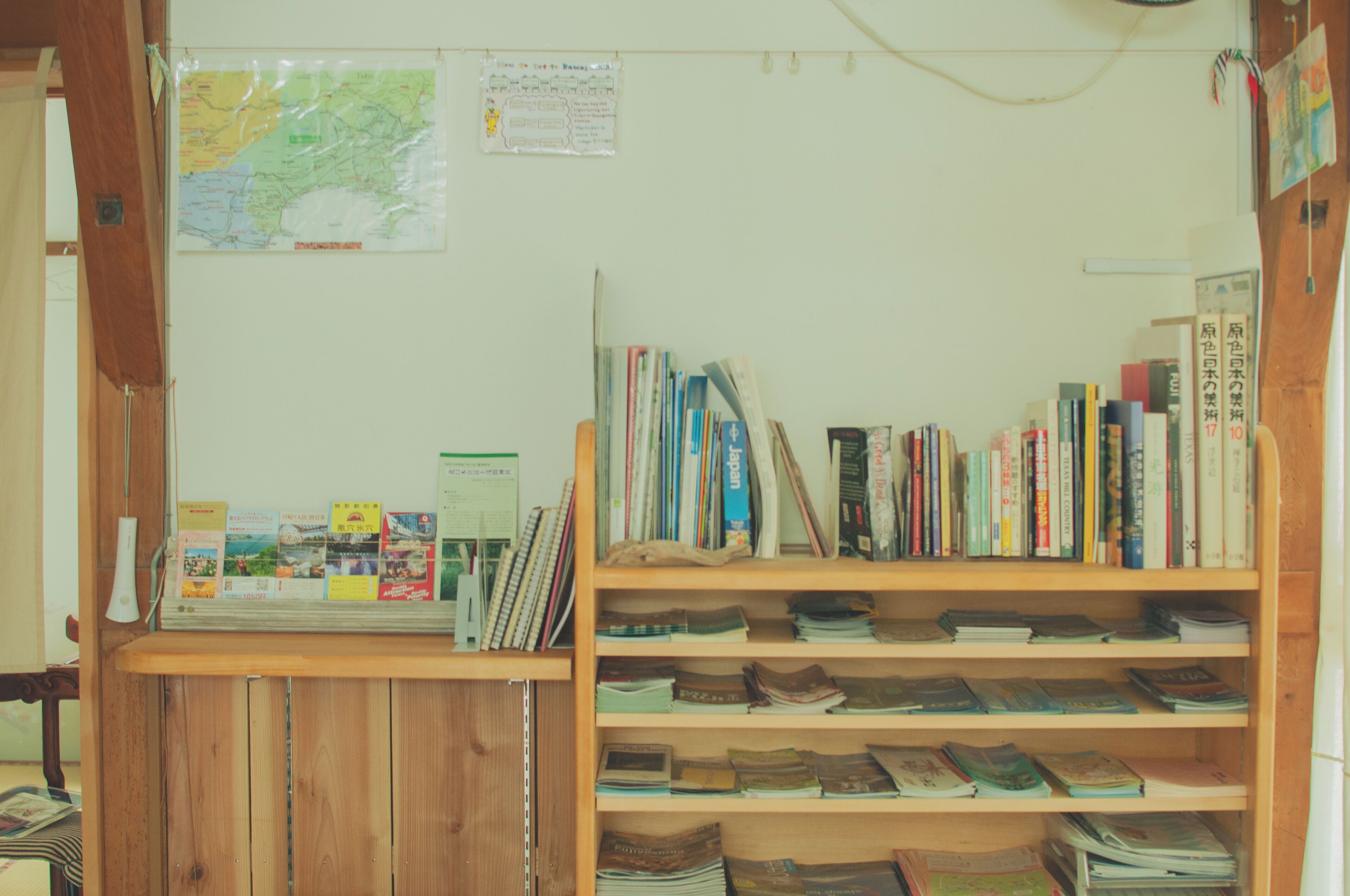 Uma biblioteca com estantes de madeira repletas de livros e um mapa na parede.