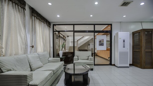 Uma sala de estar moderna com um sofá, uma mesa de centro e uma porta de vidro deslizante que dá para uma escada.
