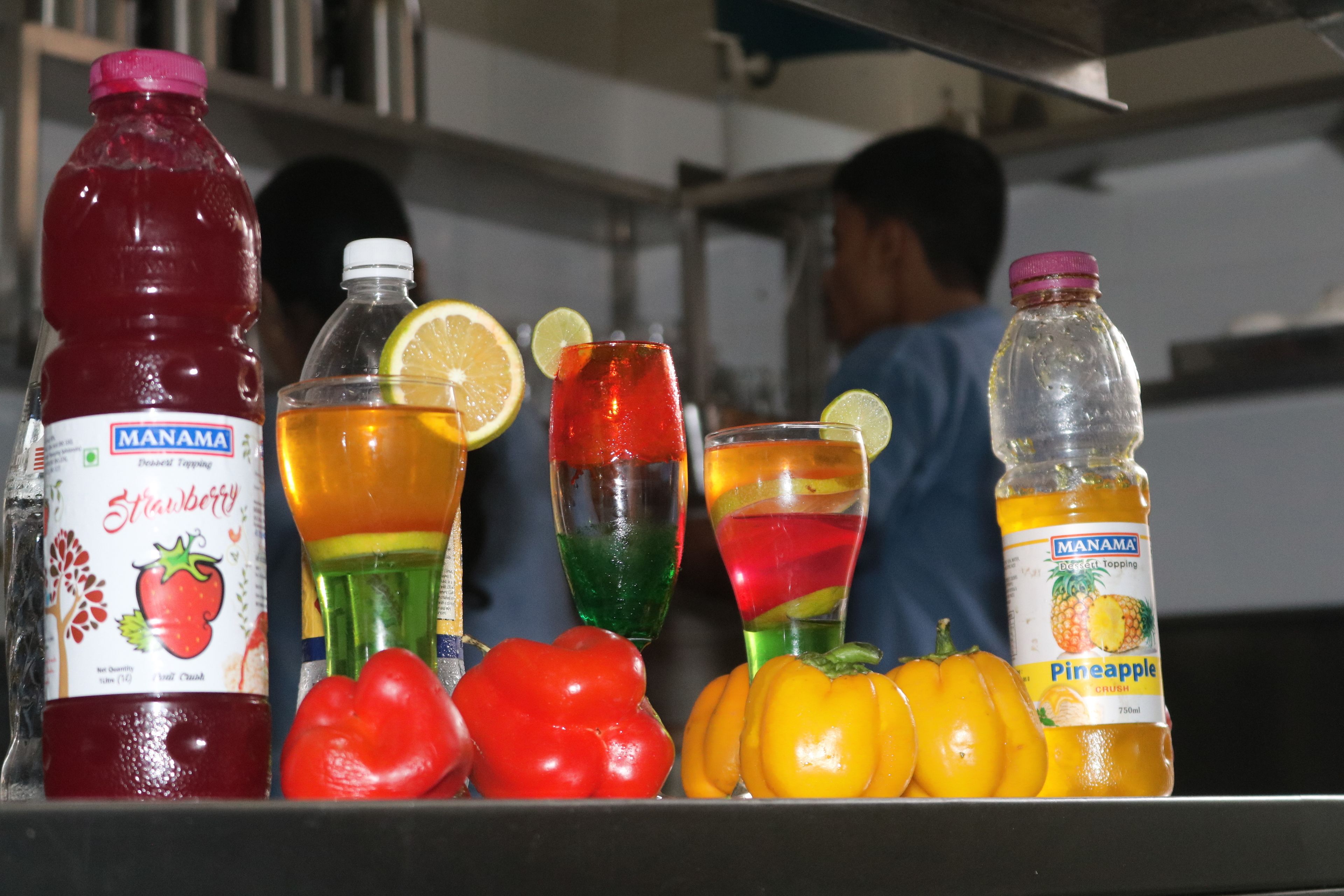 Diversas bebidas e frutas sobre um balcão.