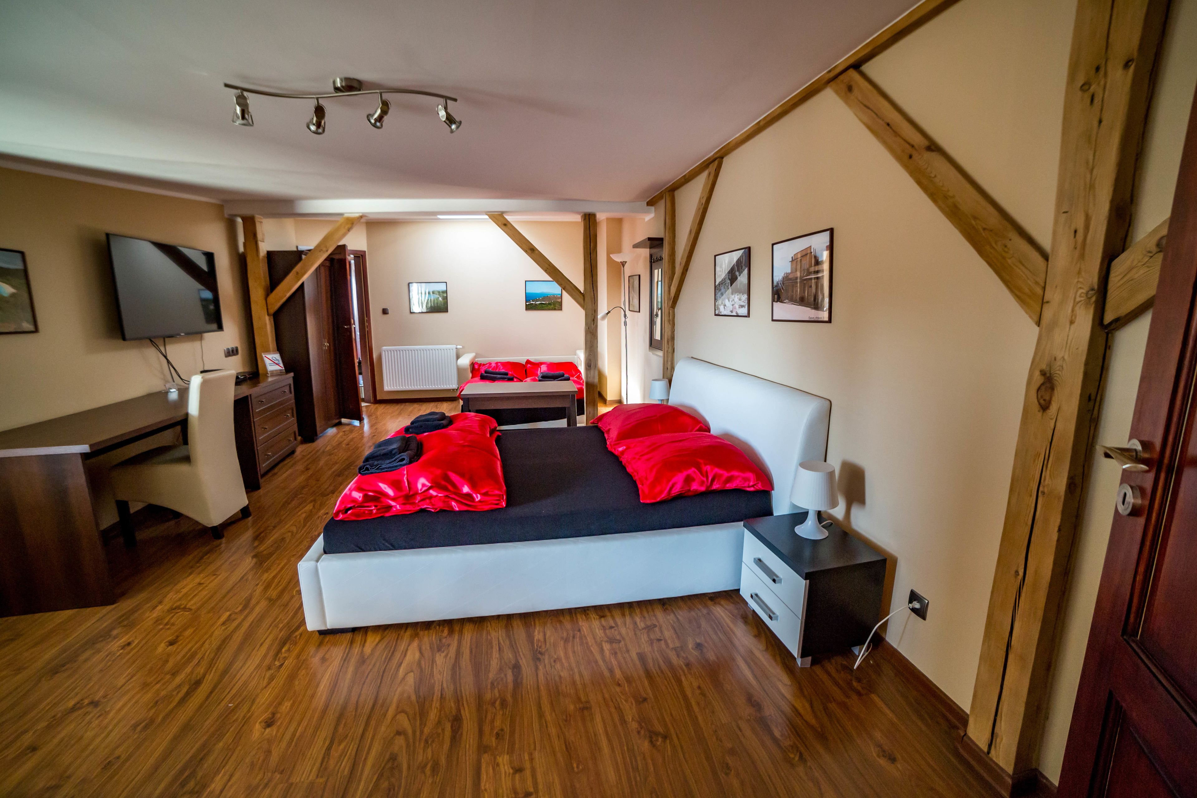 Um quarto com cama, mesa de cabeceira e escrivaninha.