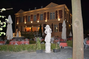 Um edifício com uma fonte, área de estar ao ar livre e uma estátua.