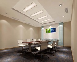 Uma sala de conferências com uma mesa comprida, seis cadeiras e uma tela grande exibindo um logotipo.