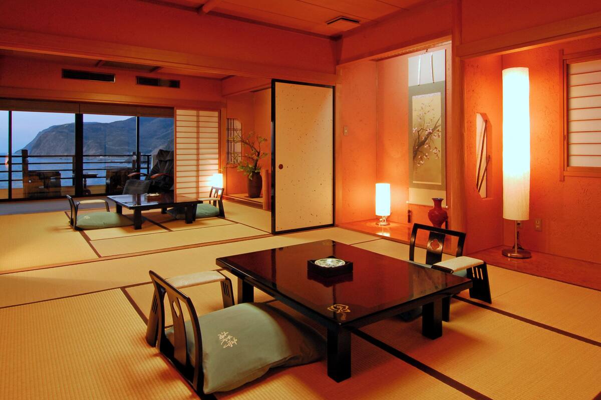 Um quarto japonês tradicional com tatames, uma mesa baixa e portas shoji.