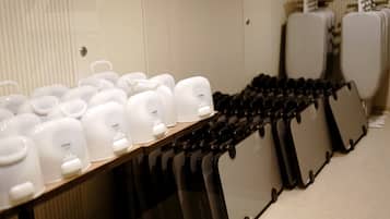 Uma fileira de eletrodomésticos brancos, possivelmente cafeteiras, em uma bancada com armários pretos.