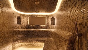 Um espaço revestido com azulejos, com um banco embutido e área de chuveiro.