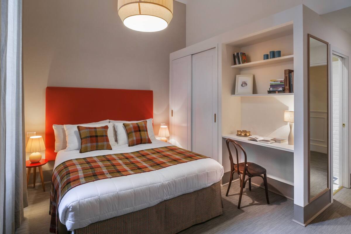 Quarto com cama, escrivaninha e guarda-roupa.
